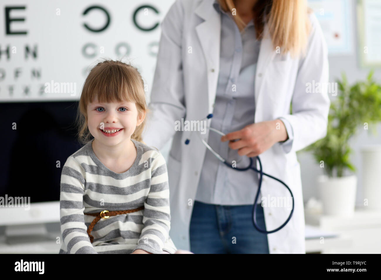Smiling cute little patient interacting with female doctor portrait ...