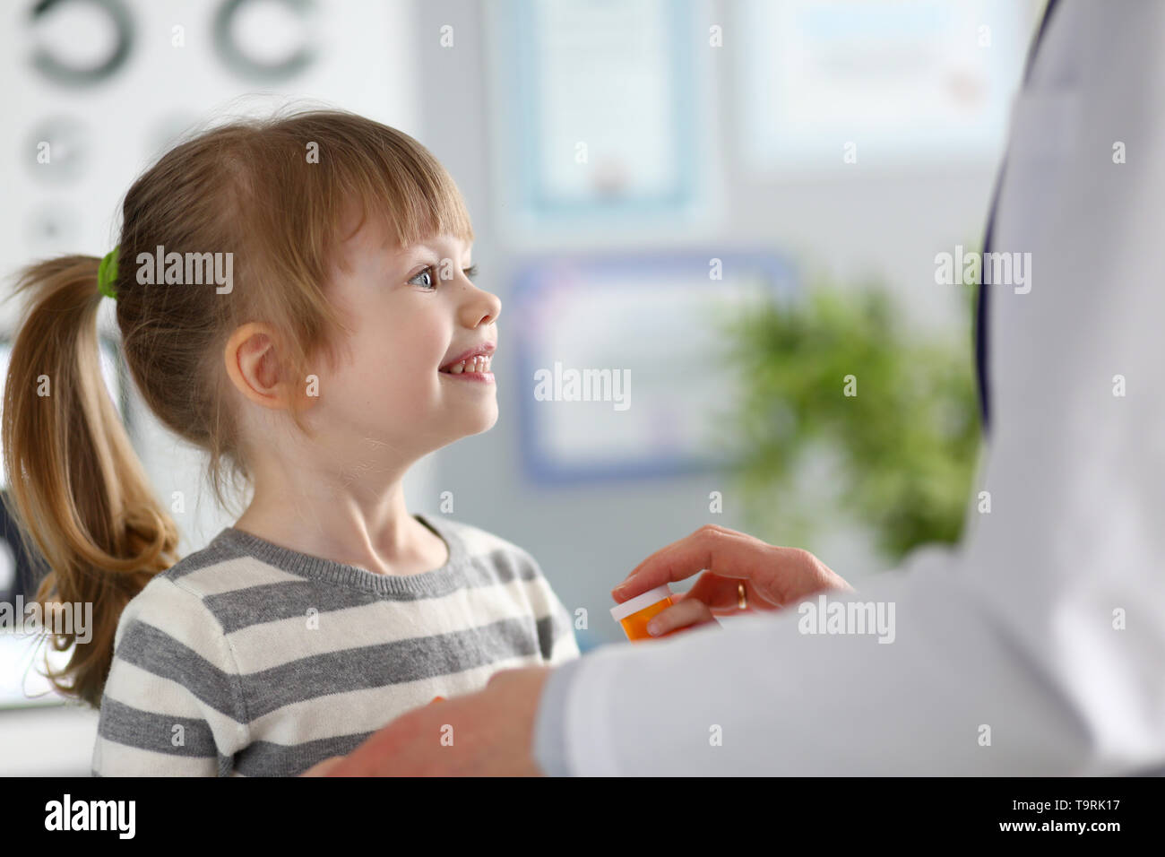 Cute little girl at doctor reception getting medications prescription ...