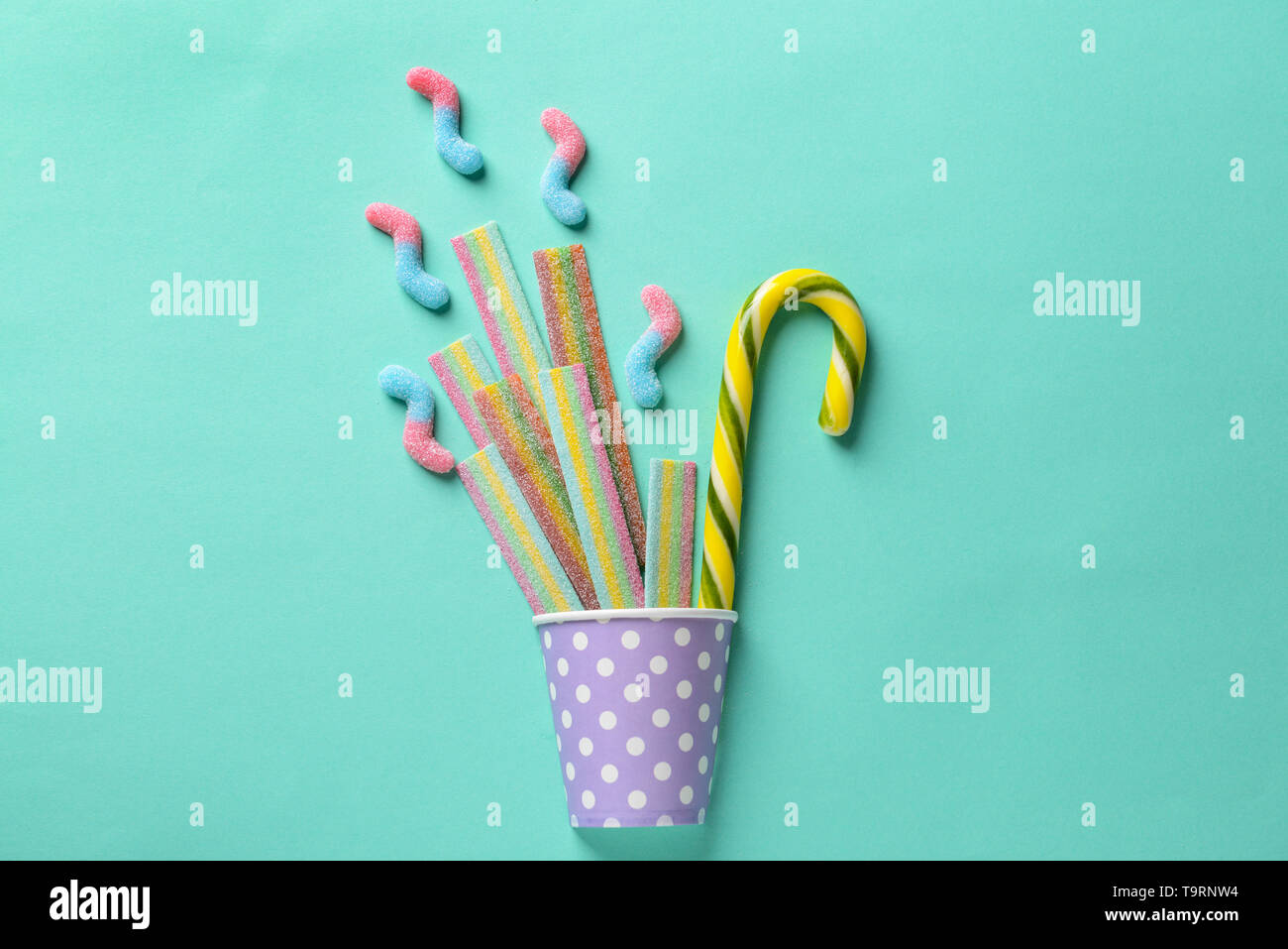 Cup with different tasty candies on color background Stock Photo - Alamy