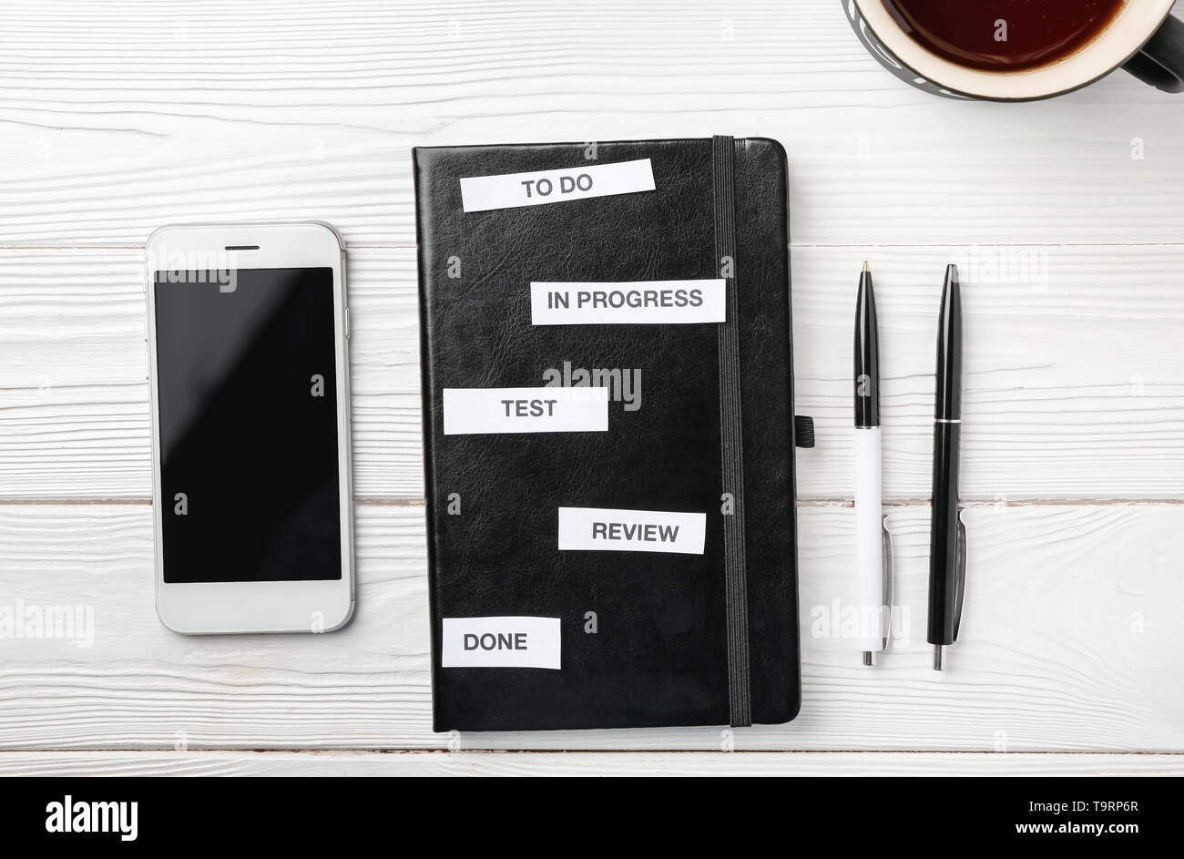 Phone and notebook with words TO DO, IN PROGRESS, TEST, REVIEW, DONE on ...