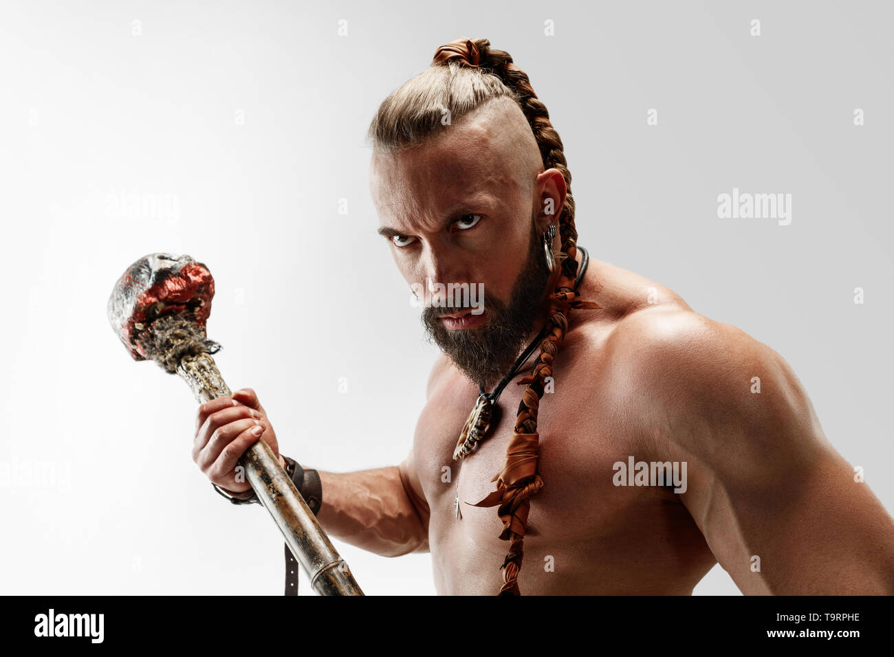 Serious long hair and muscular male model in leather viking's costume ...