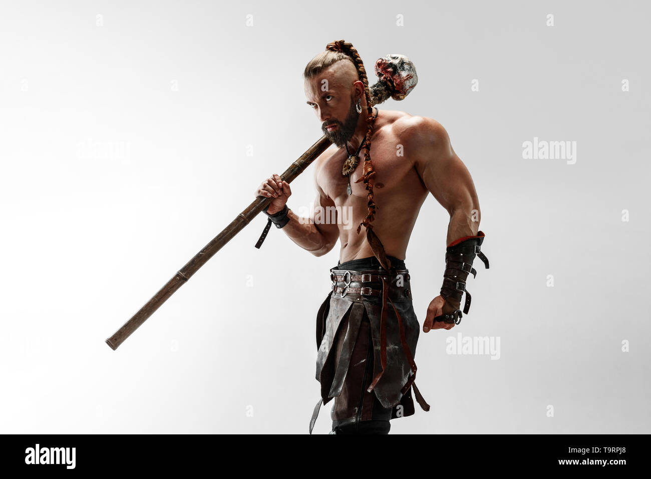 Serious long hair and muscular male model in leather viking's costume ...