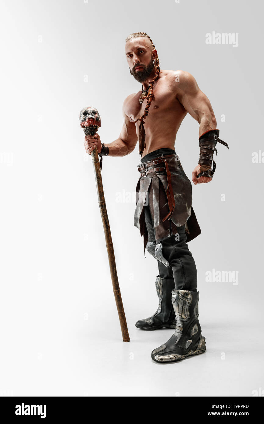 Serious long hair and muscular male model in leather viking's costume ...