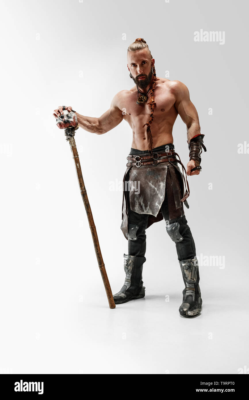 Serious long hair and muscular male model in leather viking's costume ...