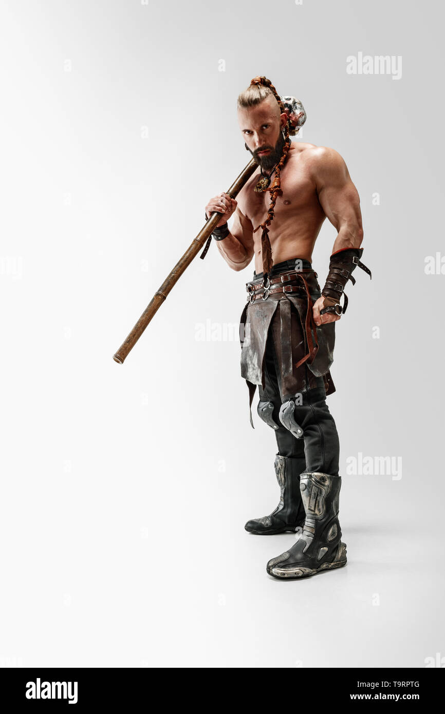 Serious long hair and muscular male model in leather viking's costume ...