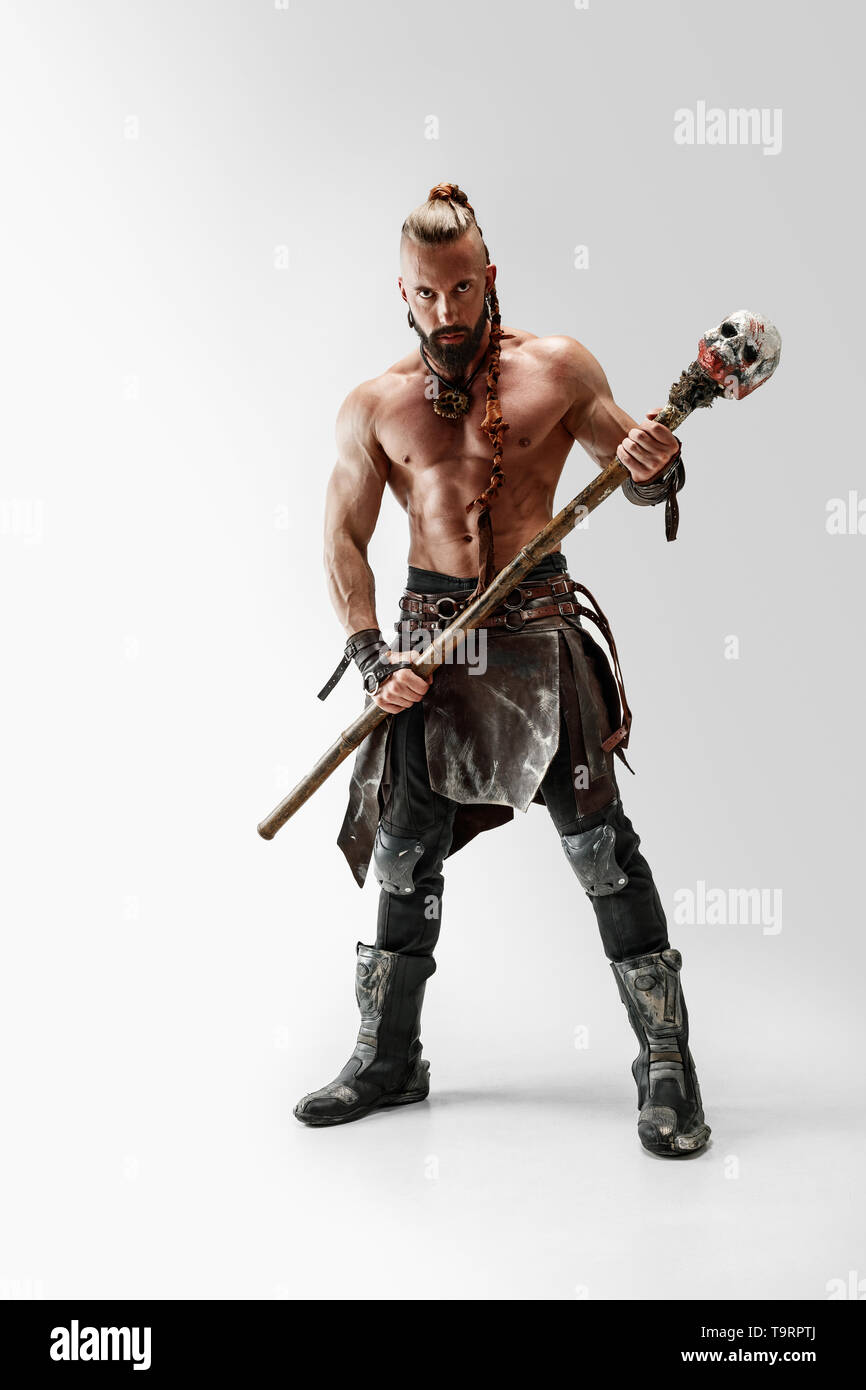 Serious long hair and muscular male model in leather viking's costume ...