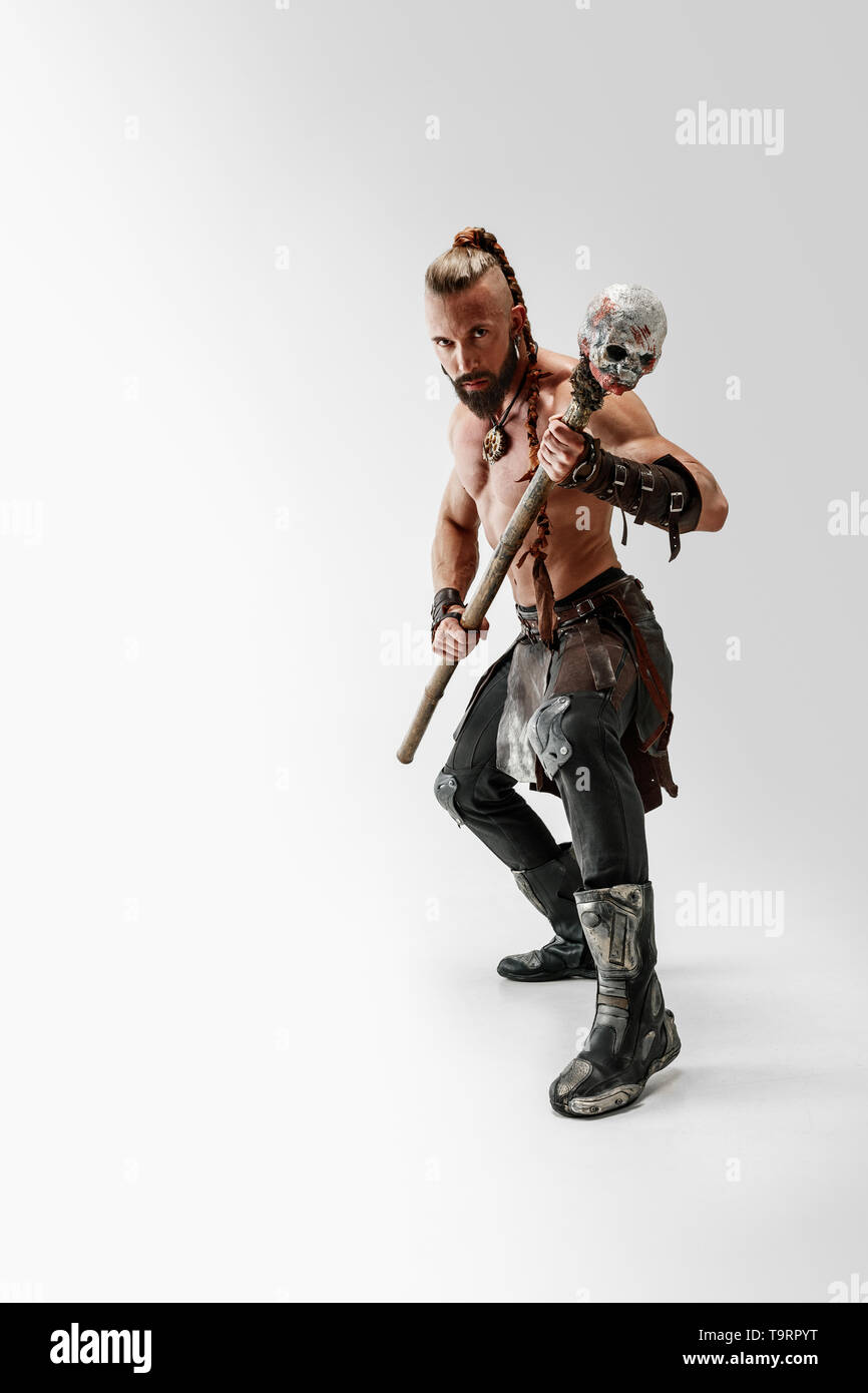 Serious long hair and muscular male model in leather viking's costume ...