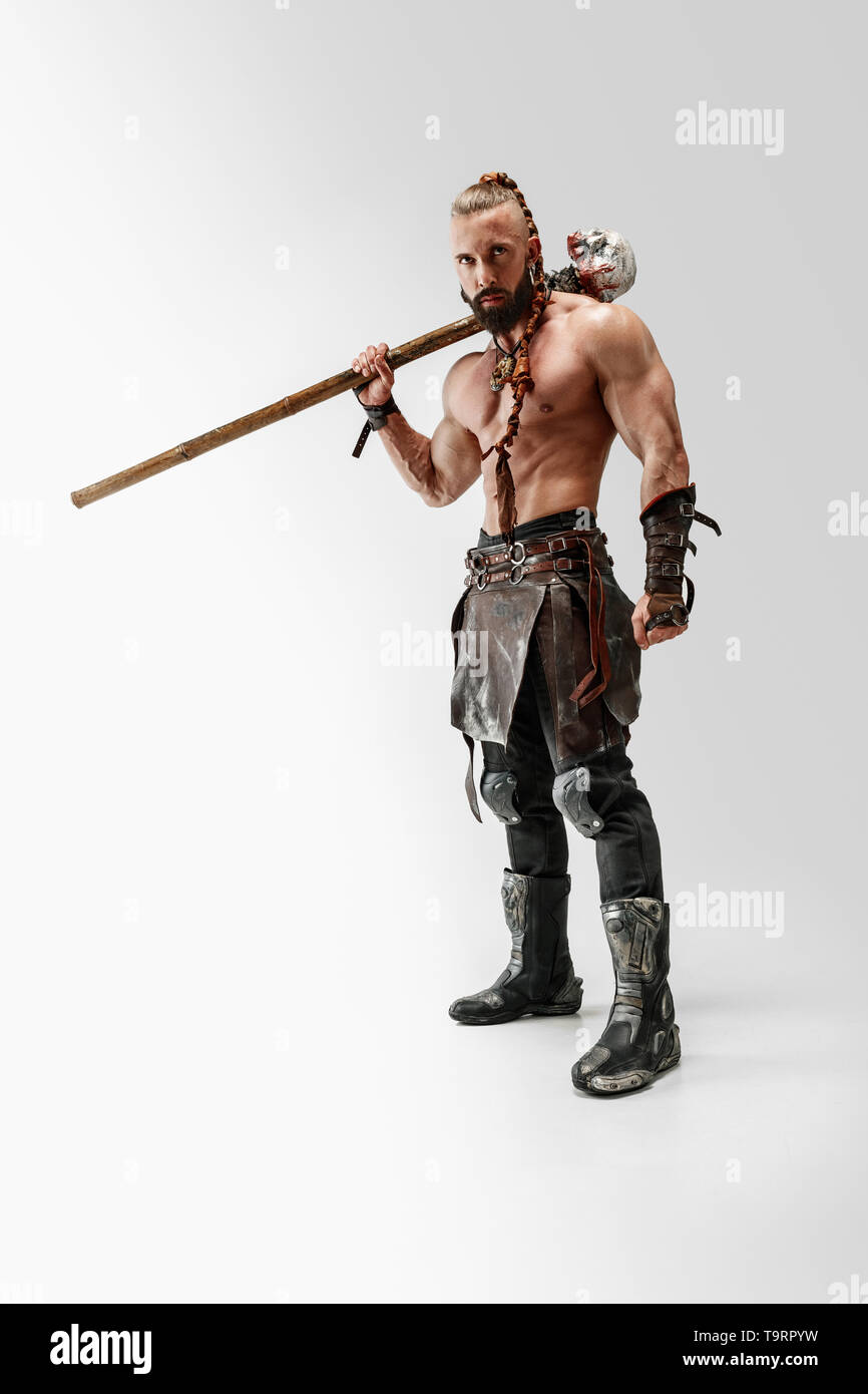Serious long hair and muscular male model in leather viking's costume ...