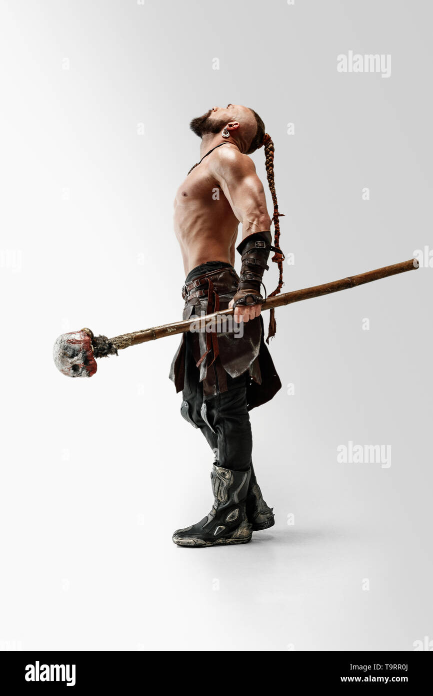 Serious long hair and muscular male model in leather viking's costume ...