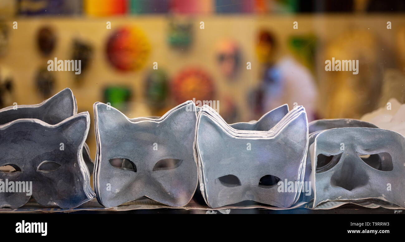 Unfinished Venetian masks lined up on a window ledge in a shop in ...