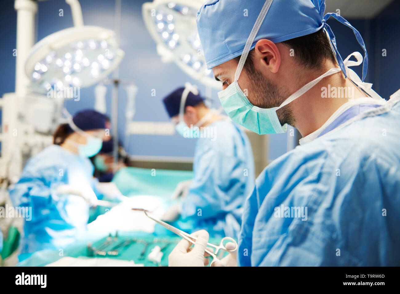 Side view of surgeon using medical scissors during an operation Stock ...
