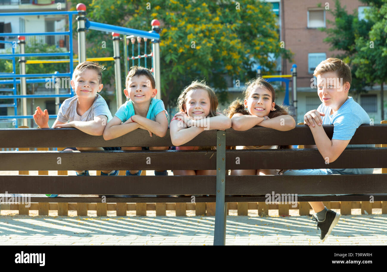 Five children sitting on a bench Stock Photo - Alamy