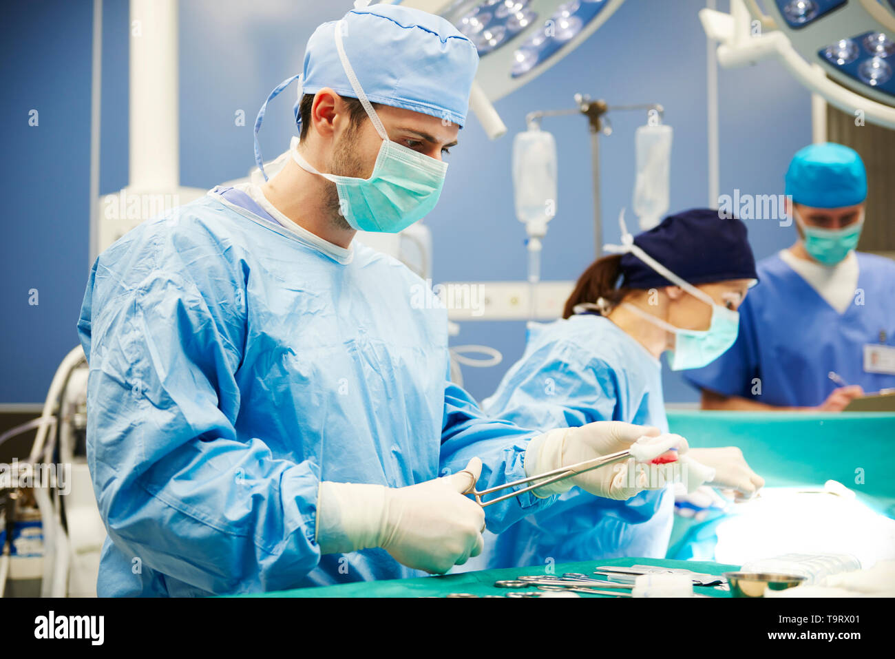 Surgeon using medical scissors while an operation Stock Photo - Alamy