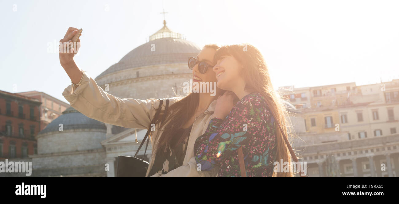 two young female tourists doing a backlight selfie Stock Photo - Alamy