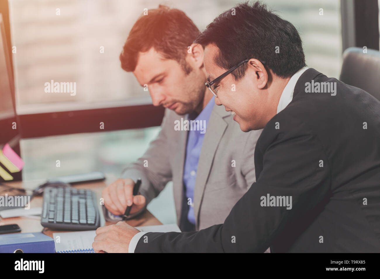 two business man talking with partner mix race Asian and Caucasian male ...