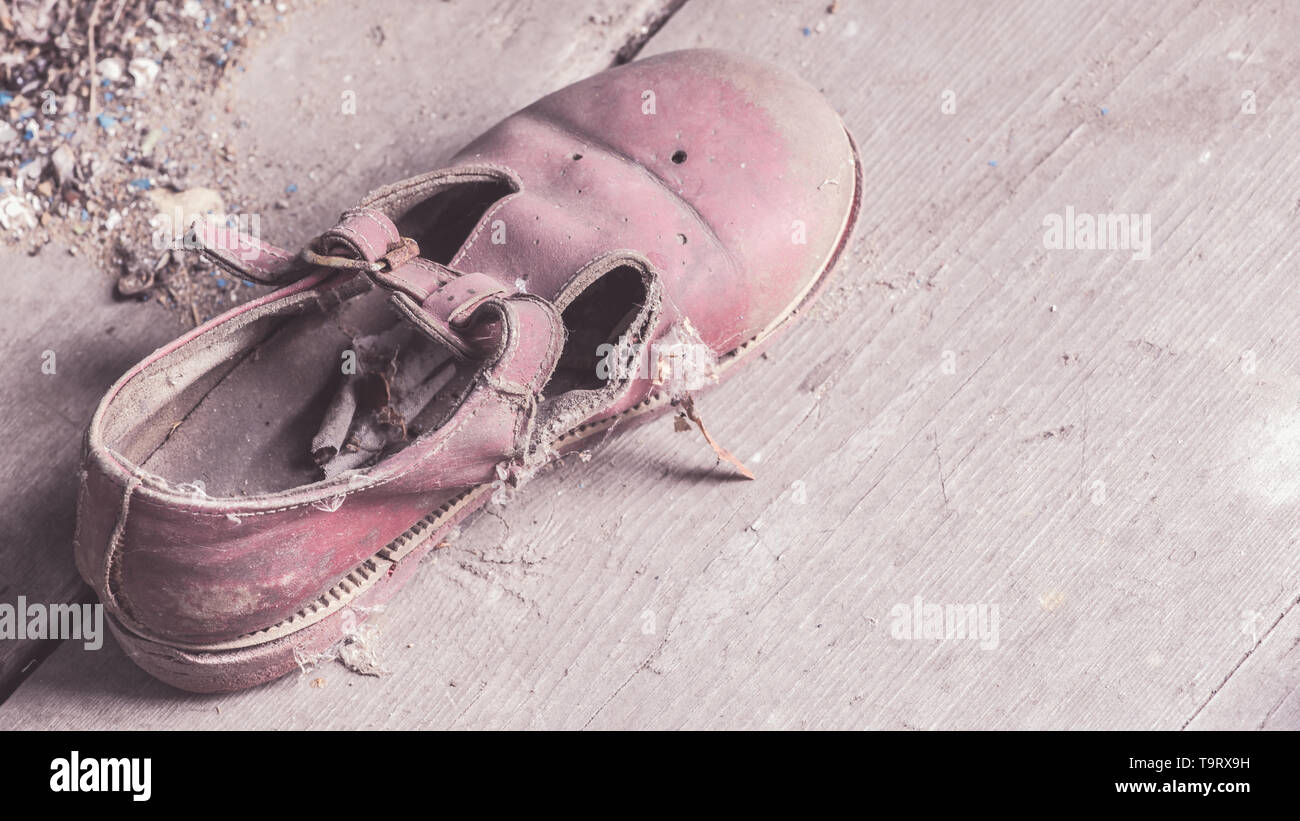 Abandoned little child shoe covered with dust in a collapsed house in ...