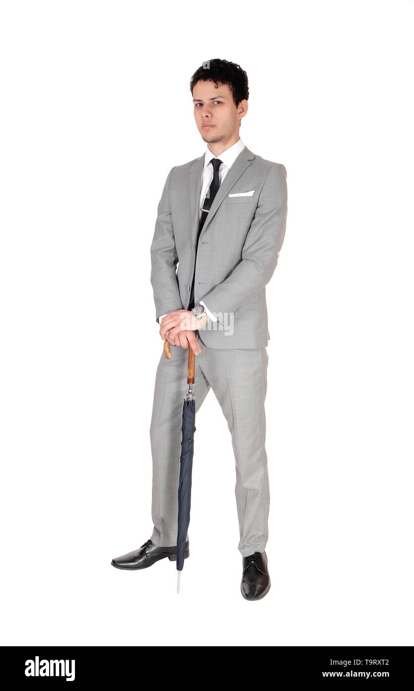 A tall young man in a light gray suit standing in a studio for white ...