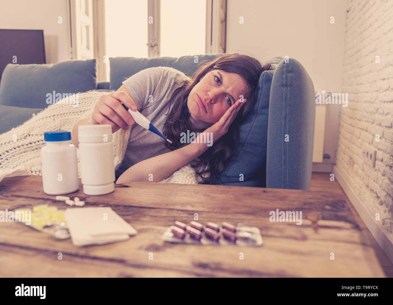 Health care and medicine. Sick woman lying on sofa at home unwell with ...