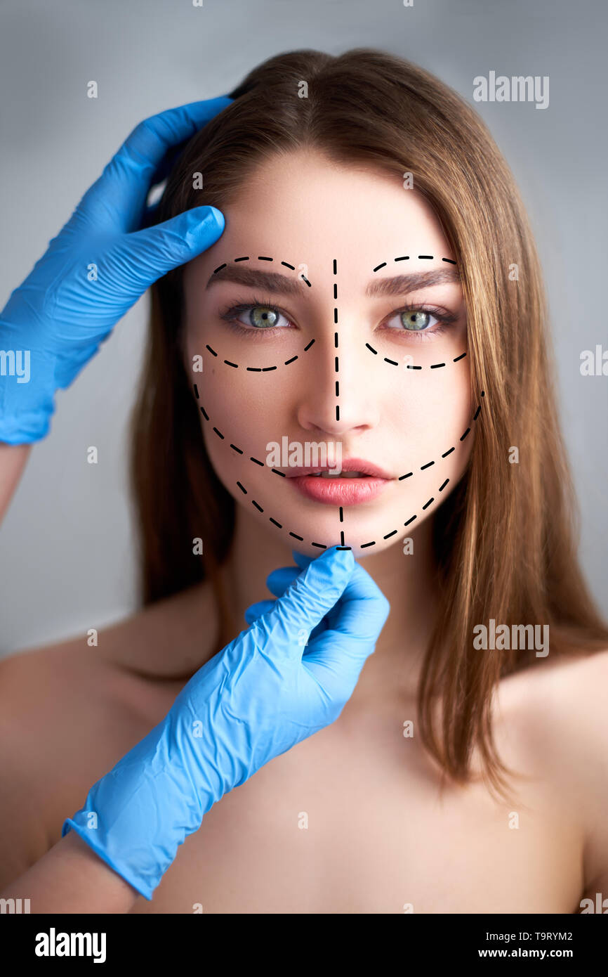 Beautiful young woman with perforation lines on her face before plastic ...