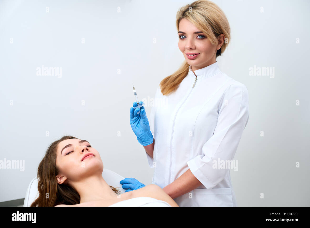 Cosmetologist doctor standing near patient and holding botulinum ...
