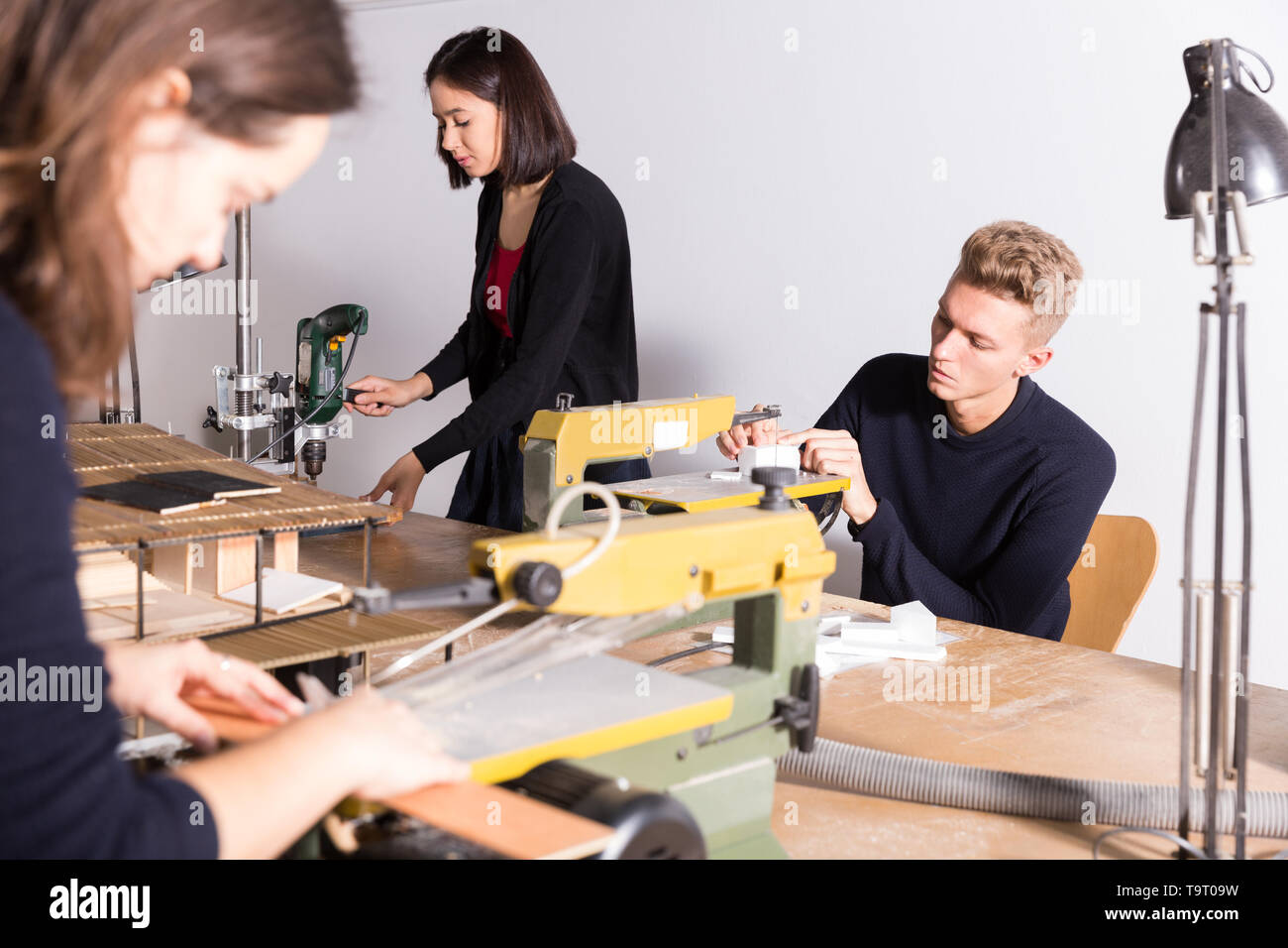 Group of focused students practicing in model workshop of architecture ...