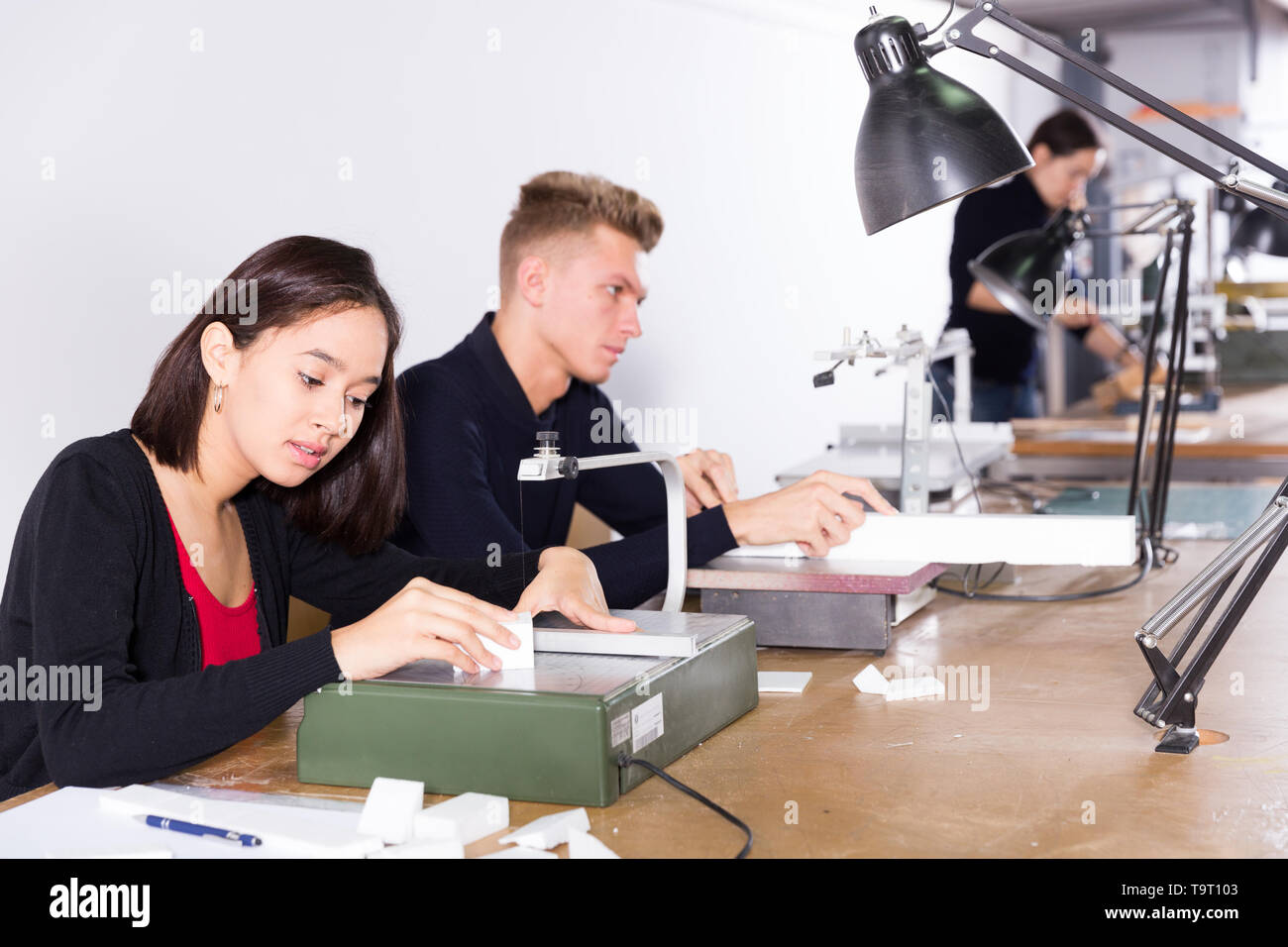 Female student of architecture faculty using scroll saw while engaged ... Female student of architecture faculty using scroll saw while engaged ...
