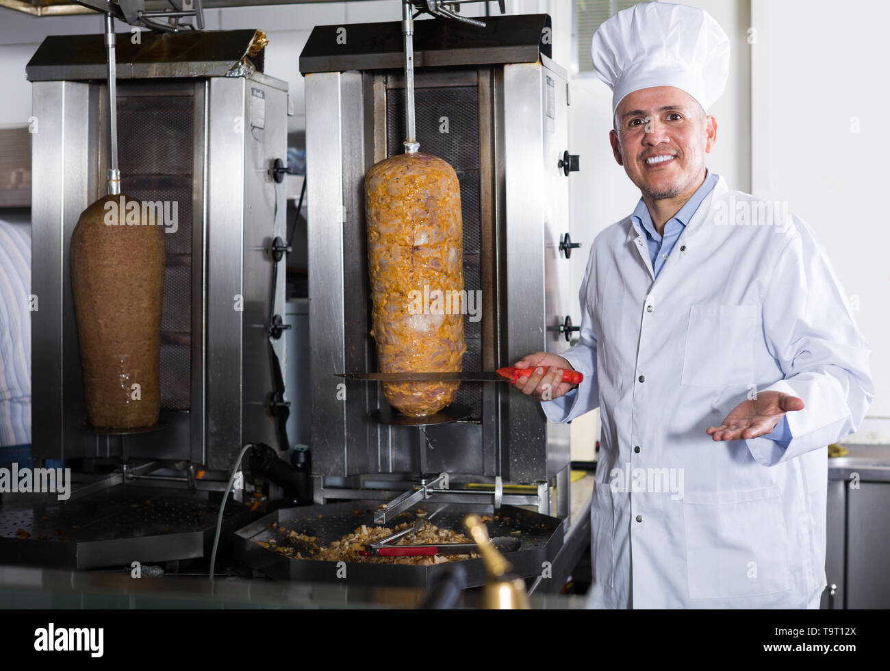 Man chef on cutting meat for kebab with special knife on kitchen in ...