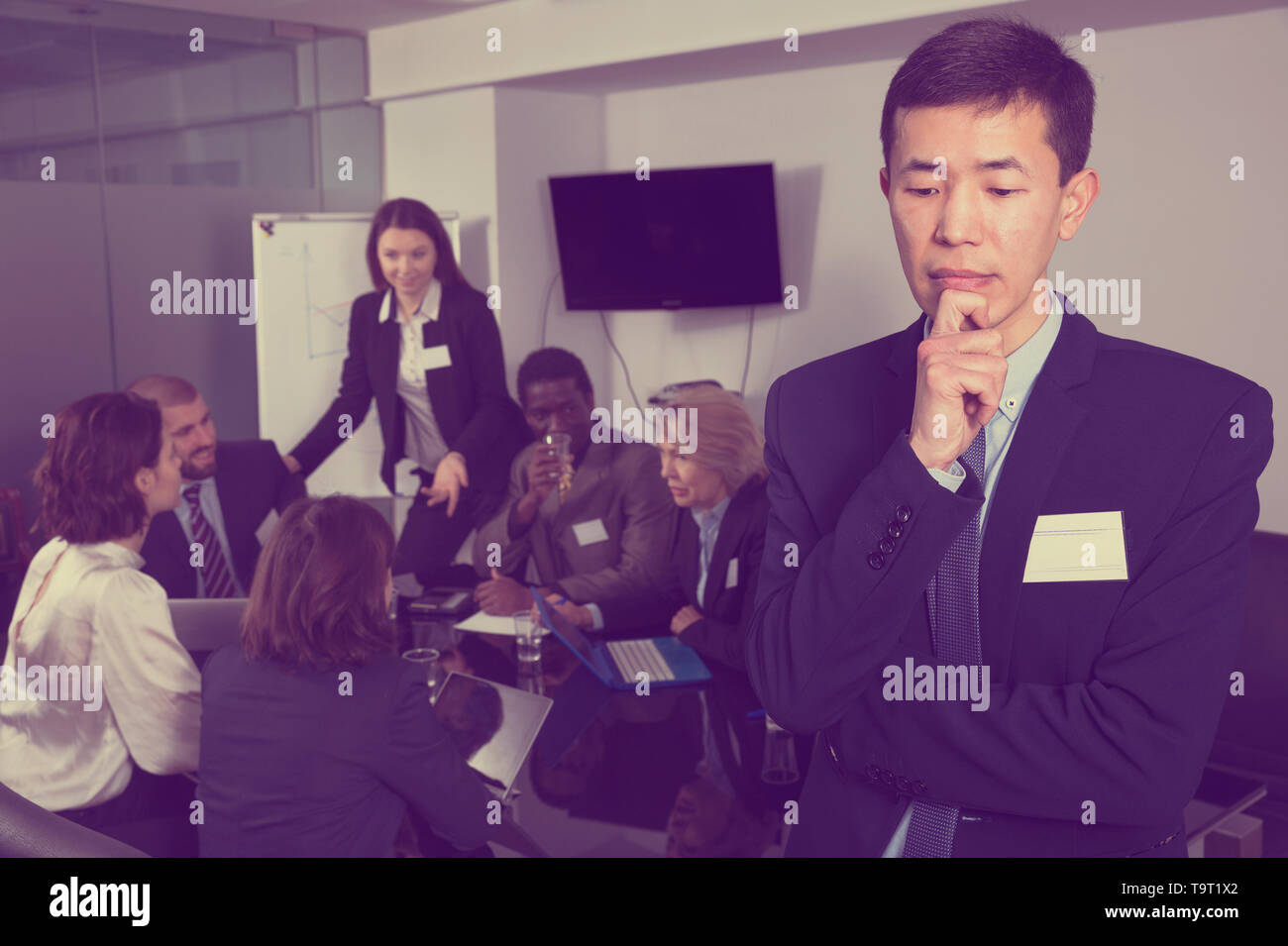 Business team discussing in meeting room with upset young Chinese man ...