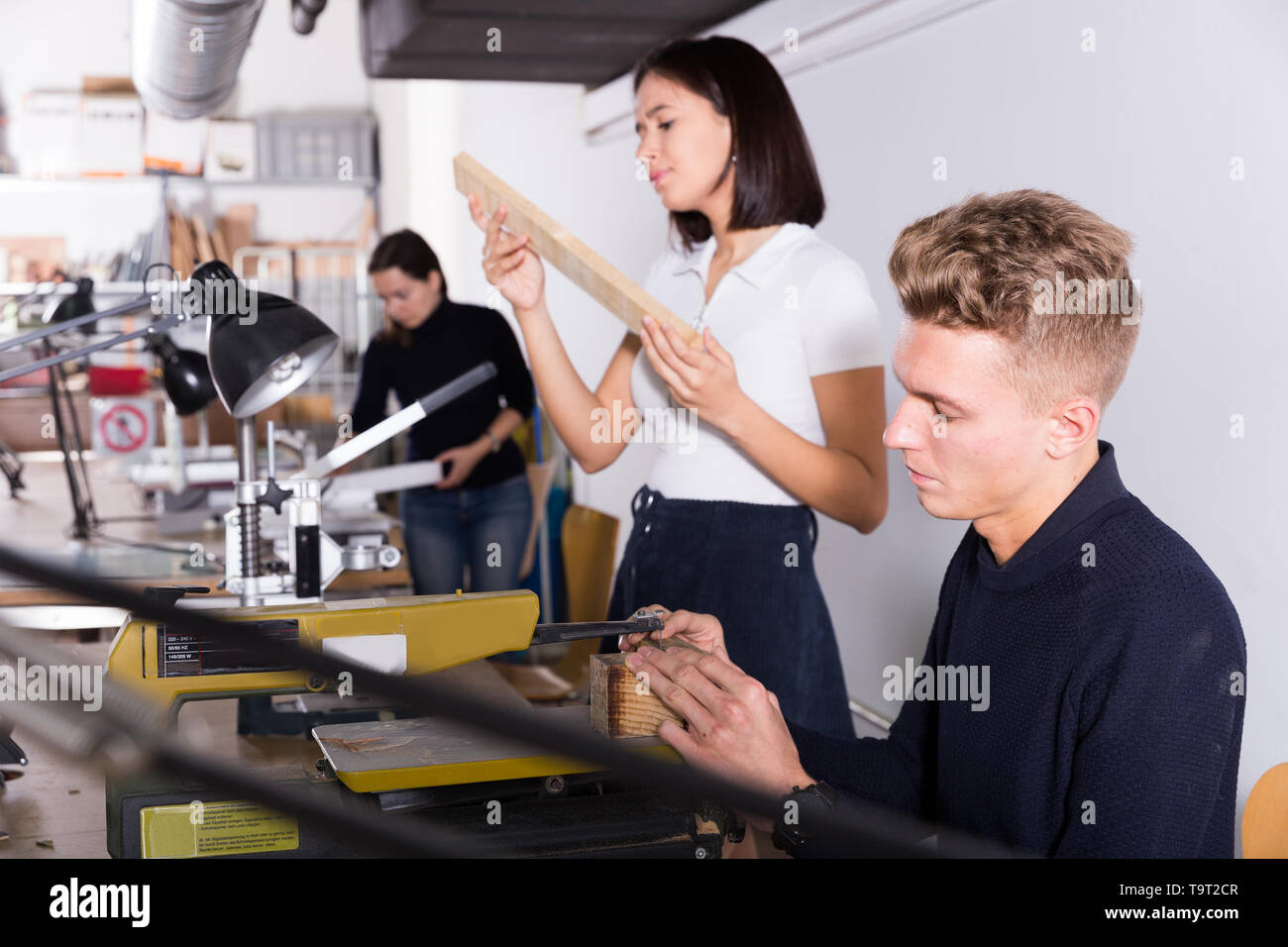 Male student of architecture faculty using scroll saw while engaged in ... Male student of architecture faculty using scroll saw while engaged in ...