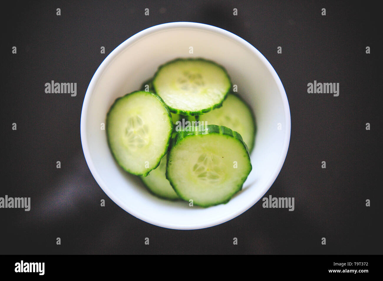 Close-up of cucumber slices in the white bowl with exotic green color ...