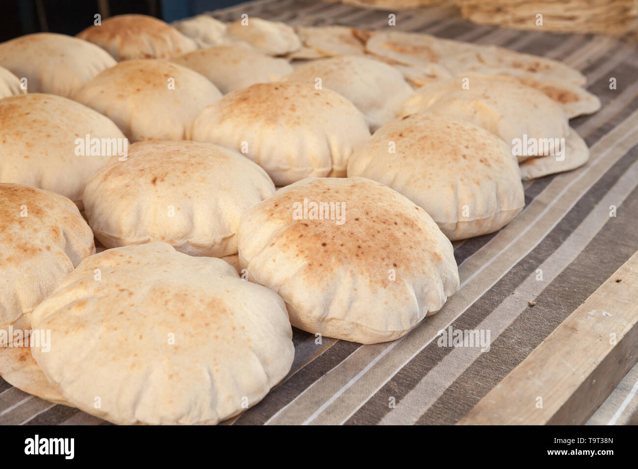 Homemade Kuboos, traditional pitta bread lie on a table of street ...