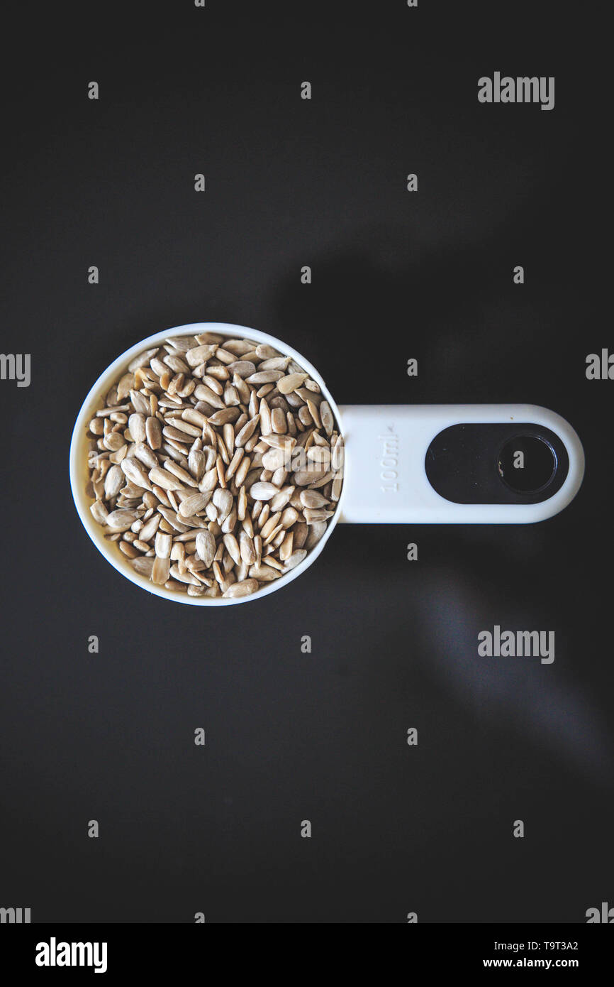 Natural sunflower seeds without shell in the white measuring cup taken ...