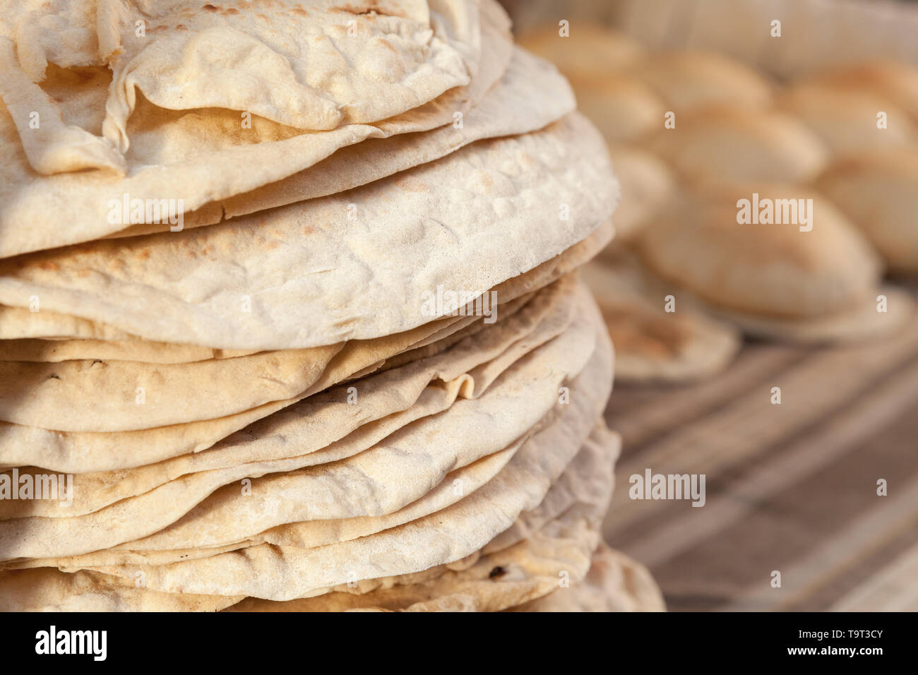 Homemade Kuboos. Stacked traditional pitta bread lie on a counter of ...