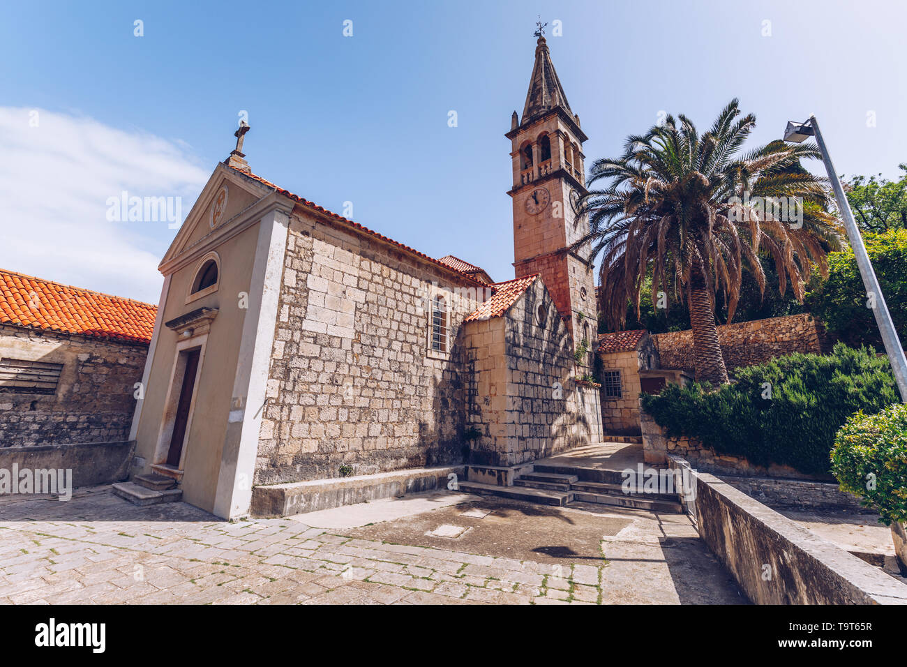 Church building and palm tree against sunny blue sky in Splitska ...