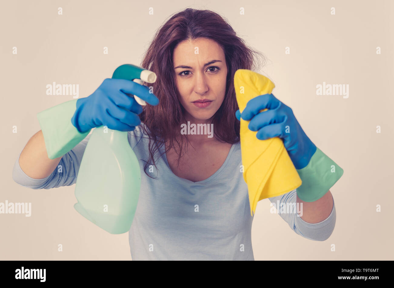 Angry and upset woman with cleaning spray and cloth cleaning feeling ...