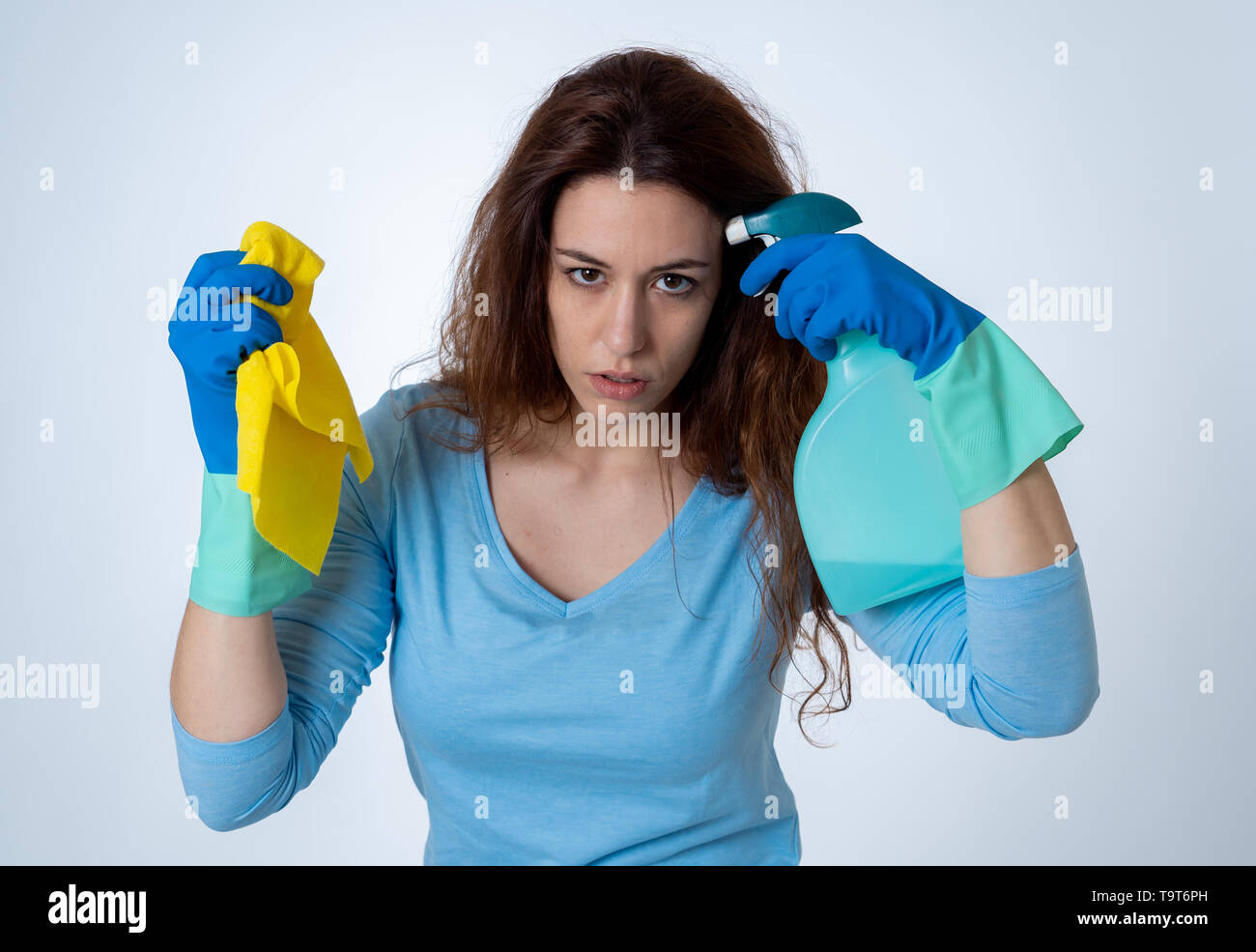 Beautiful angry and upset woman holding mop and cleaning spray feeling ...