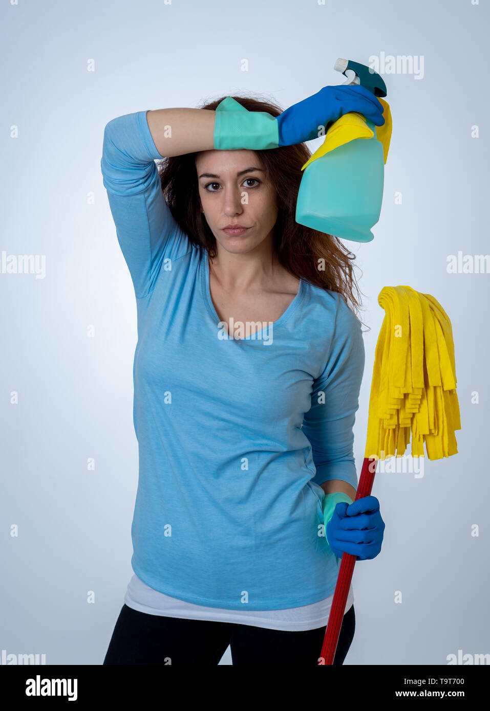 Young beautiful tired and overwhelmed housewife woman holding bucket ...