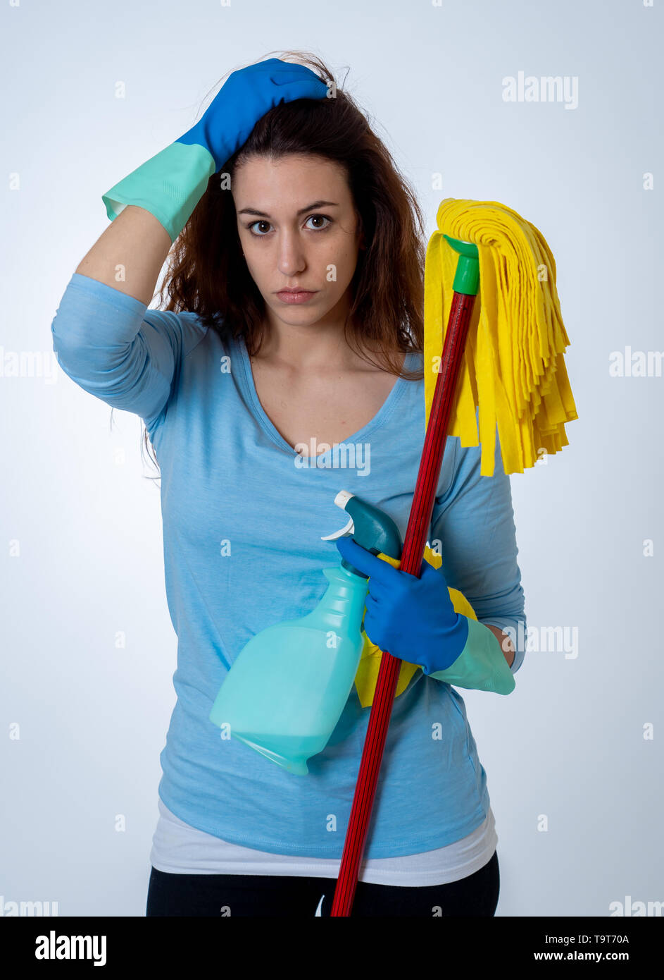 Young beautiful tired and overwhelmed housewife woman holding bucket ...