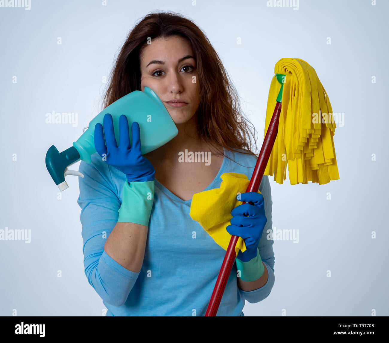 Young beautiful tired and overwhelmed housewife woman holding bucket ...