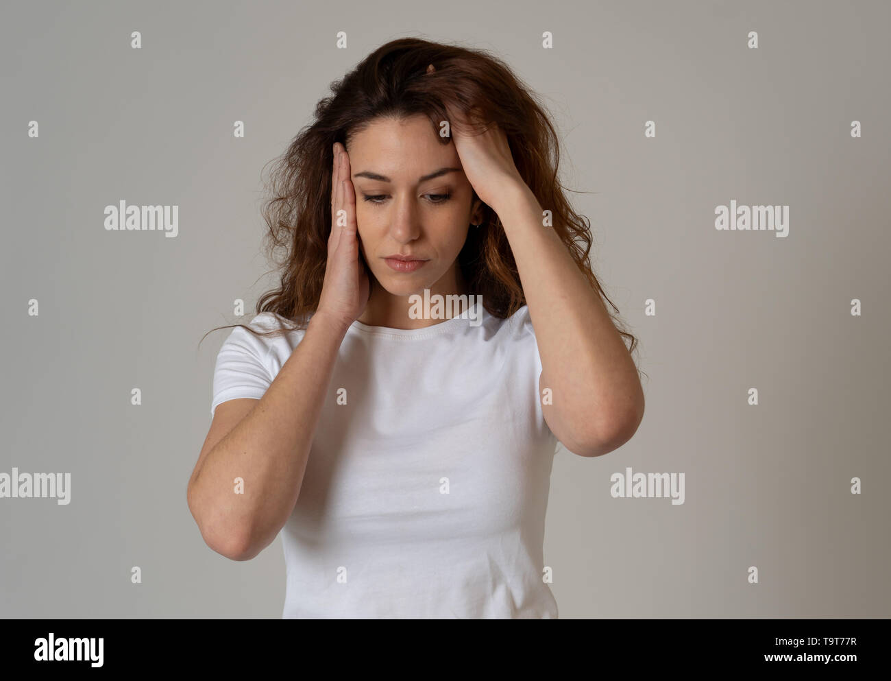 Close up portrait of a young woman looking worried and thoughtful ...