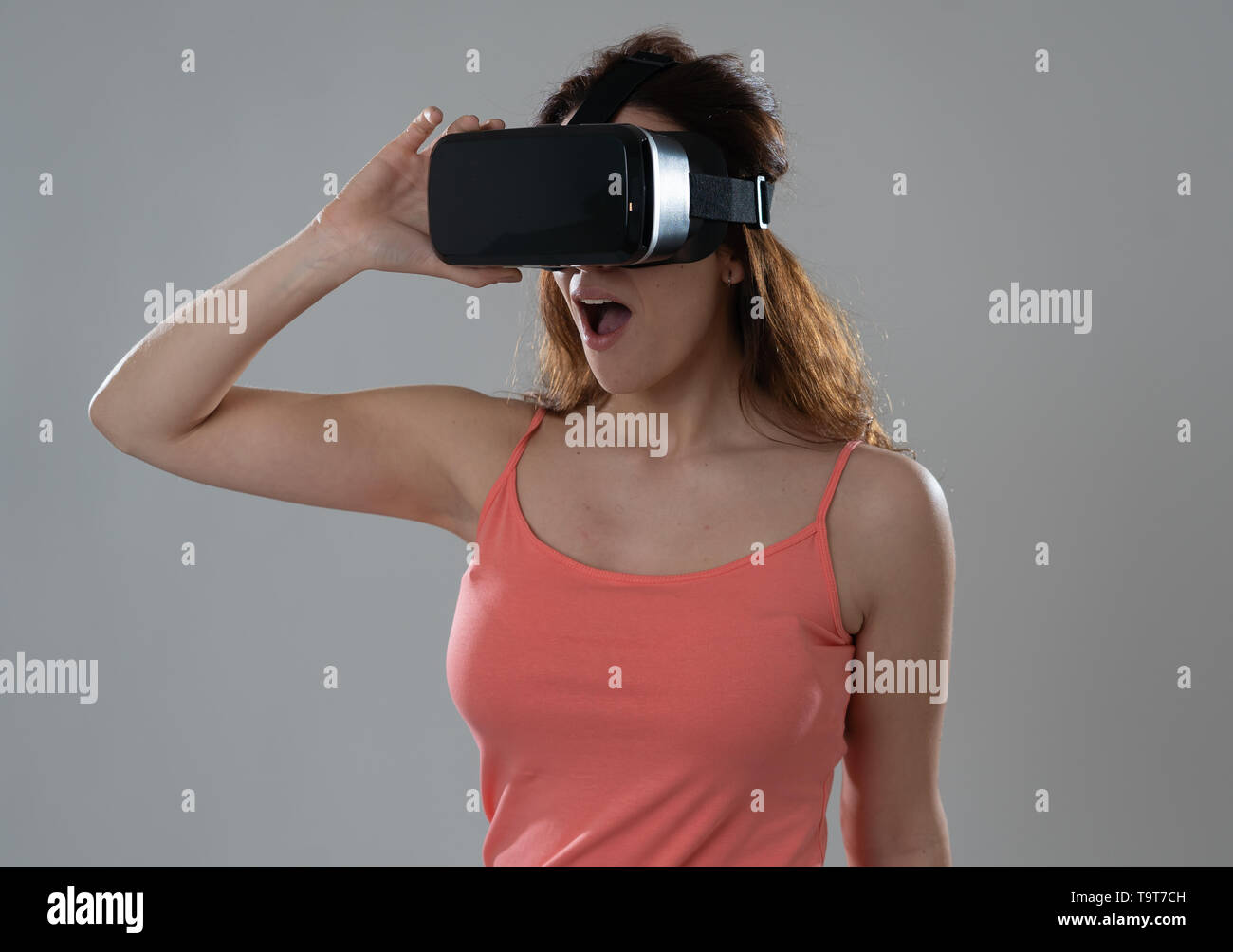 Curious woman happy and excited to use virtual reality goggles feeling ...