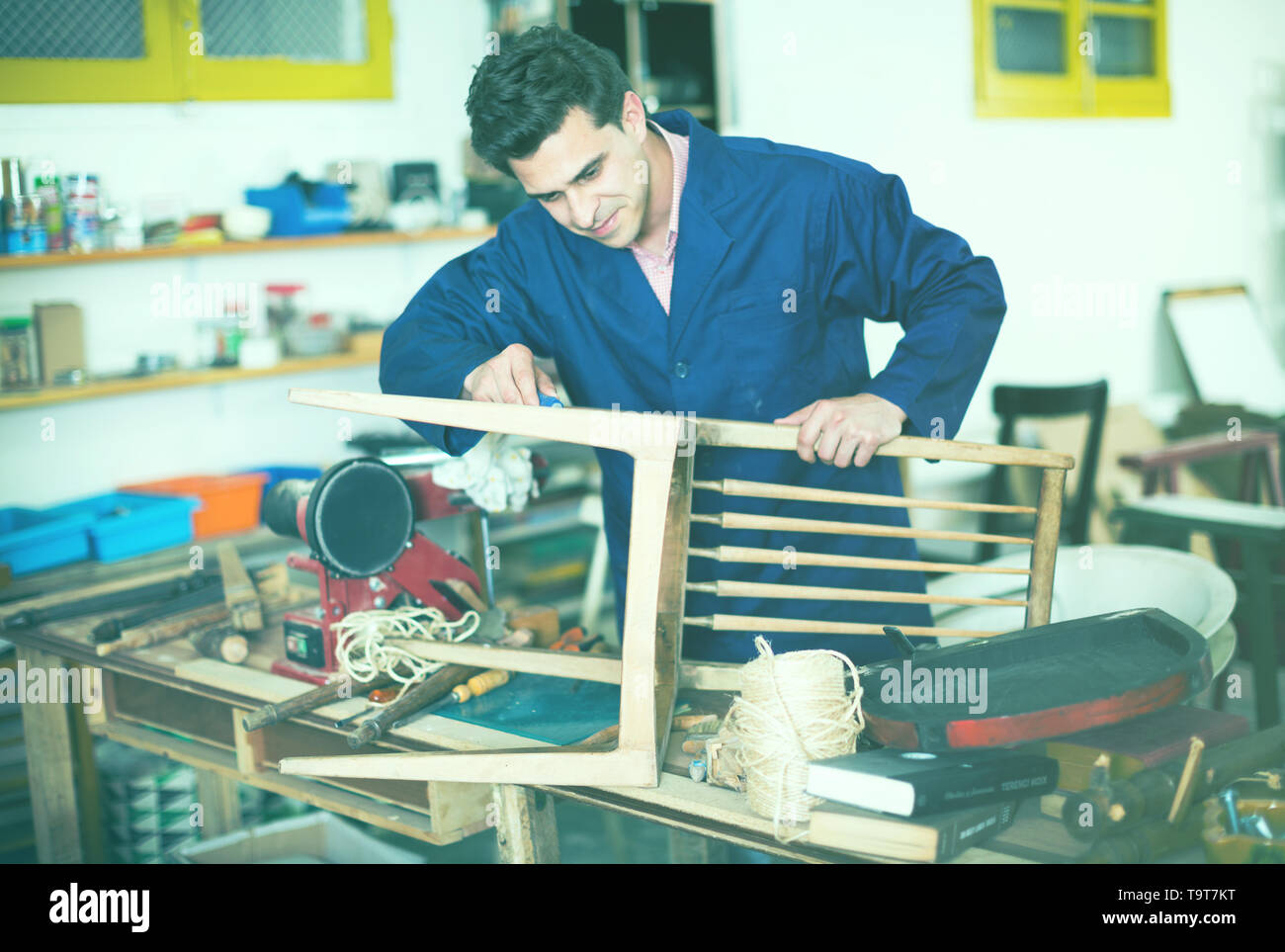 Carpenter working in repair studio and repairing broken wooden ...