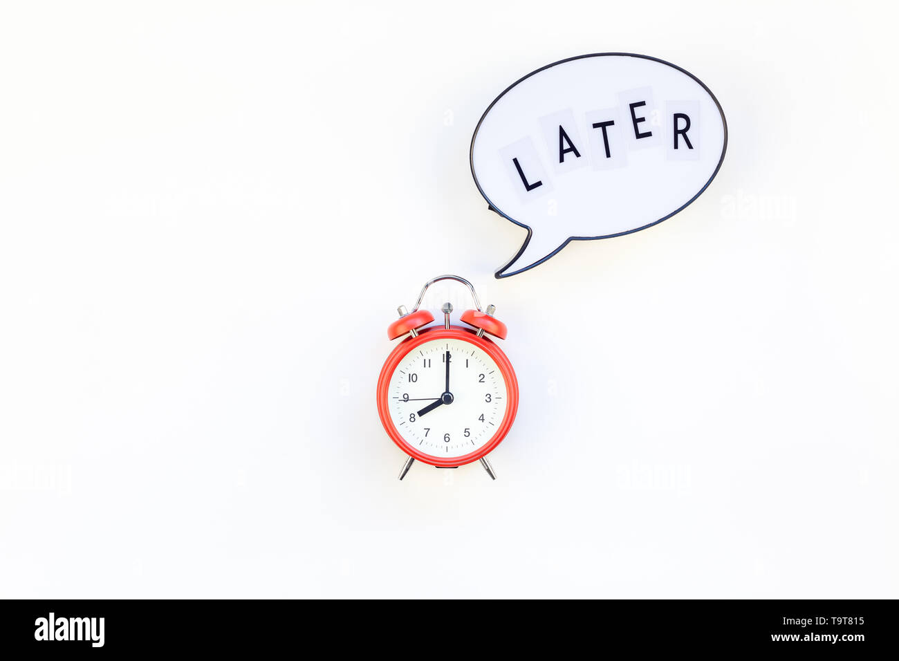 Creative top view flat lay of alarm clock with message Later copy space ...