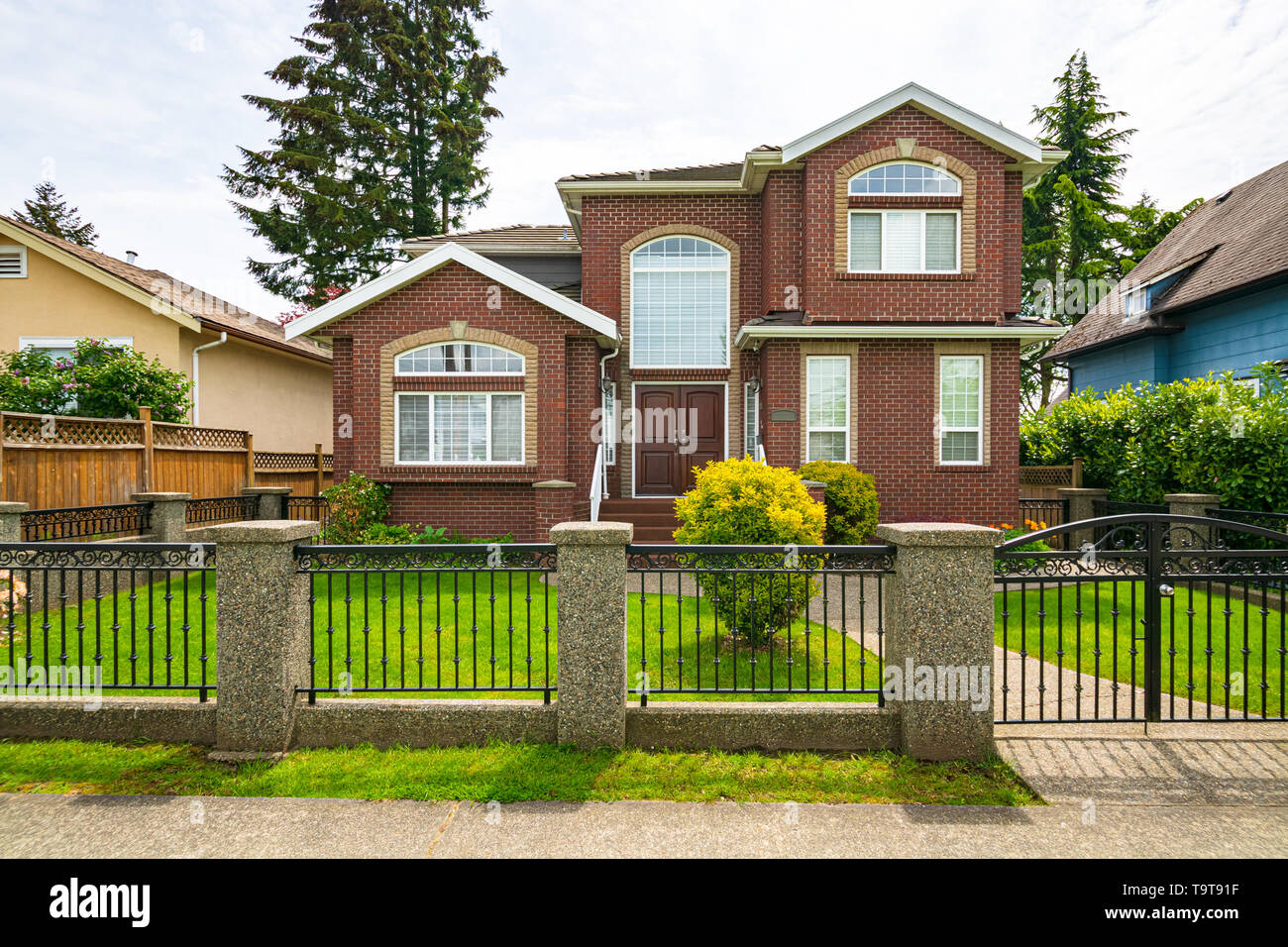 Luxury big family house with metal fence in front Stock Photo - Alamy