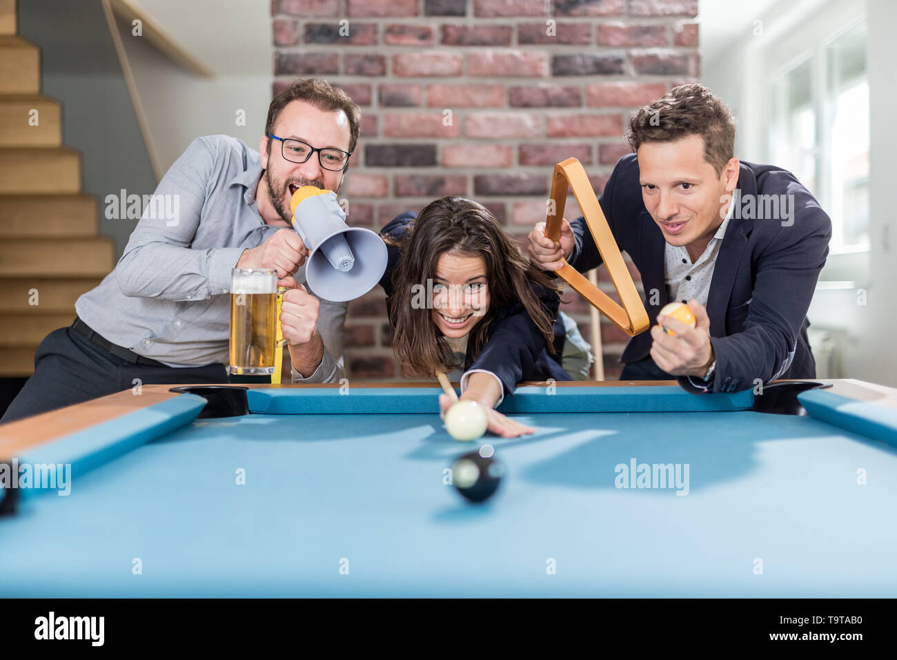 Happy friends enjoying playing snooker game Stock Photo - Alamy