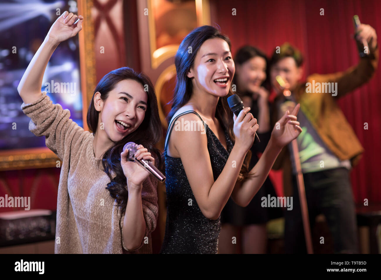 Four people singing karaoke hi-res stock photography and images - Alamy