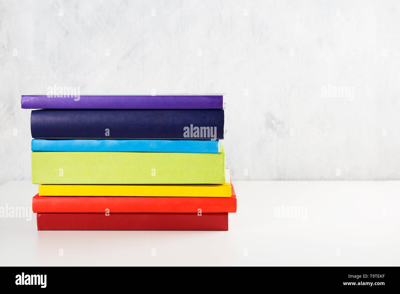 Stack of colorful rainbow books on white background. Copy space Stock ...