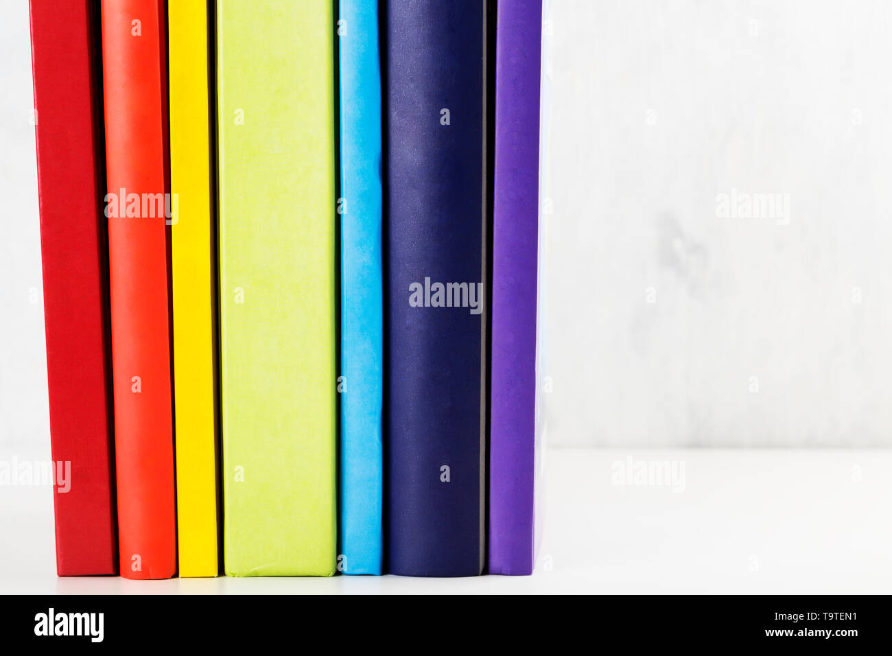 Stack of colorful rainbow books on white background. Copy space Stock ...