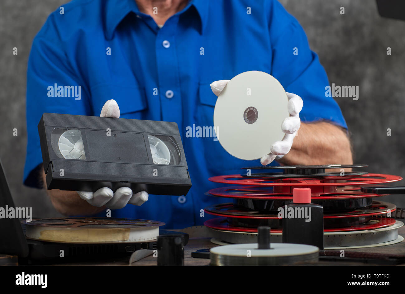 hand photographer holding a VHS tape and DVD disc for conversion Stock ...