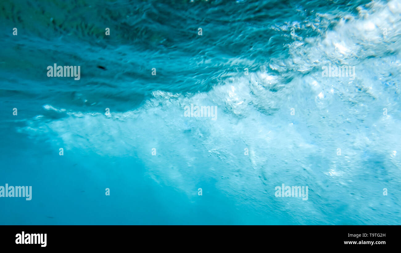 Beautiful image from under the water on rolling and swirling sae wave ...